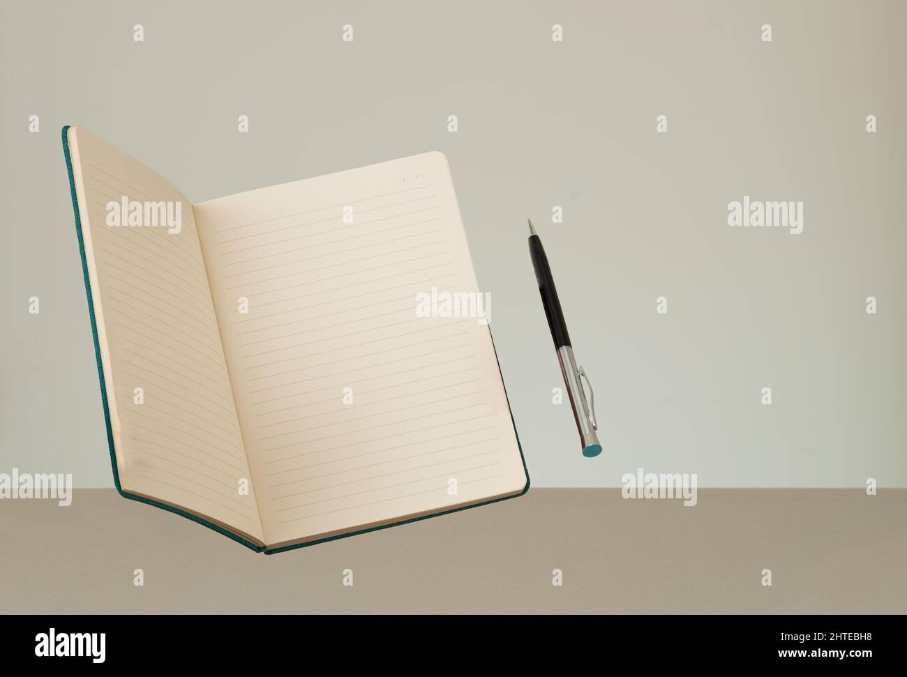 Close up photo of floating notebook and pen. Notebook blank page mockup ...