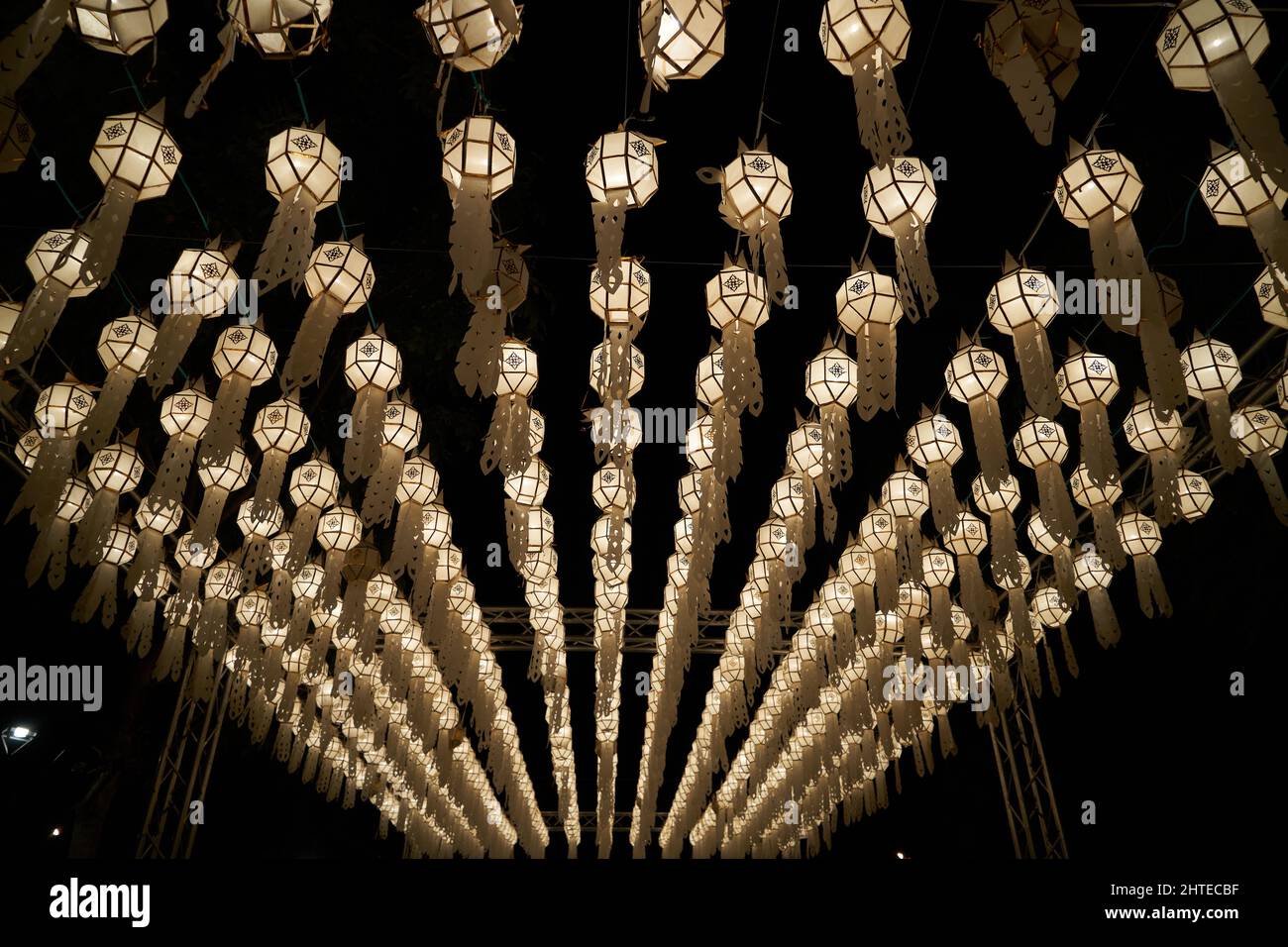 Lighted decorative Asian paper lamps in rows outdoors on a dark night ...