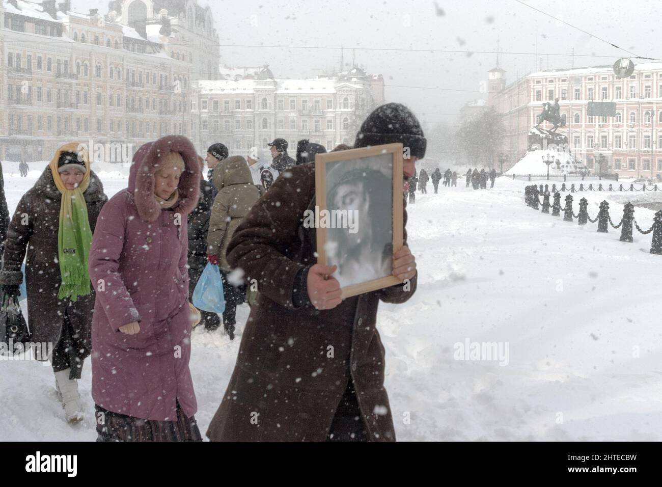 Close-up shot of a priest carrying the icon of Jesus Christ in winter ...