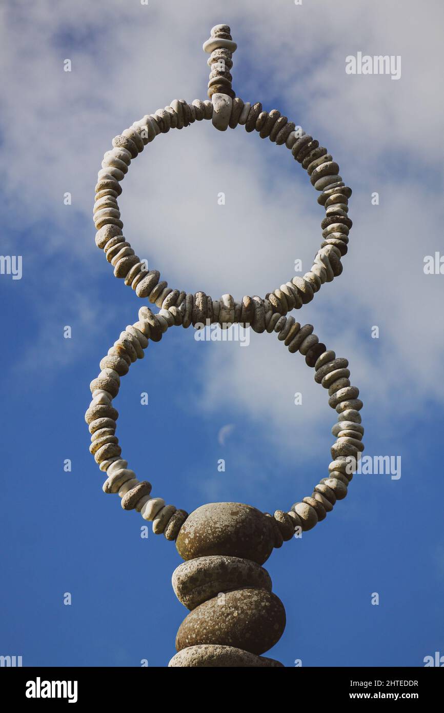 Vertical shot of balanced pebbles at the Matauri Bay under a blue ...