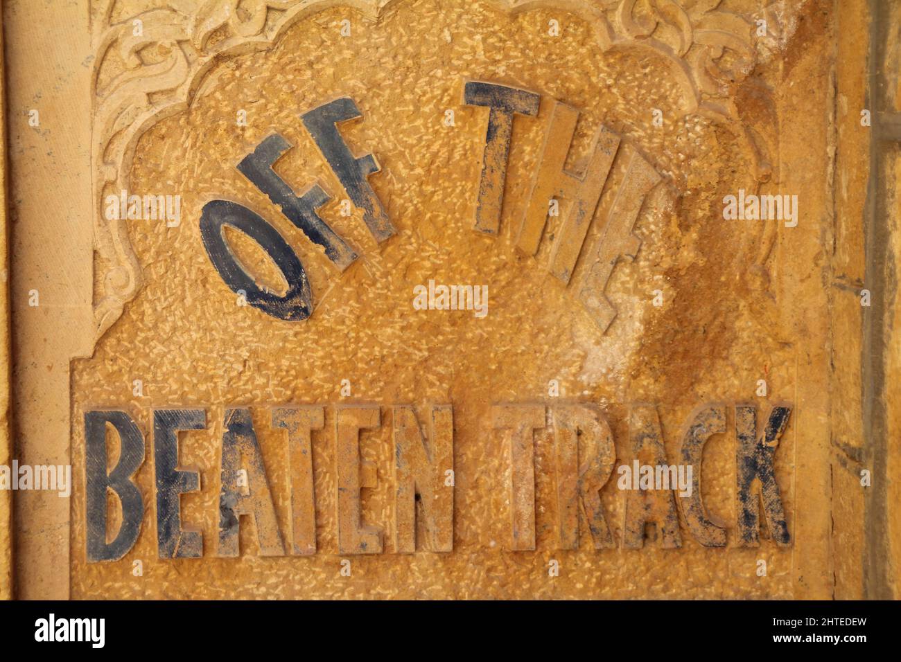 Sign "OFF THE BEATEN TRACK" on the weathered stone wall, Jaipur, India ...