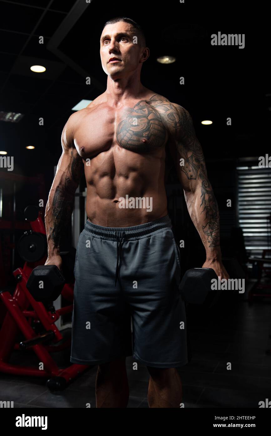 Athlete Working Out Biceps With Dumbbells Stock Photo - Alamy