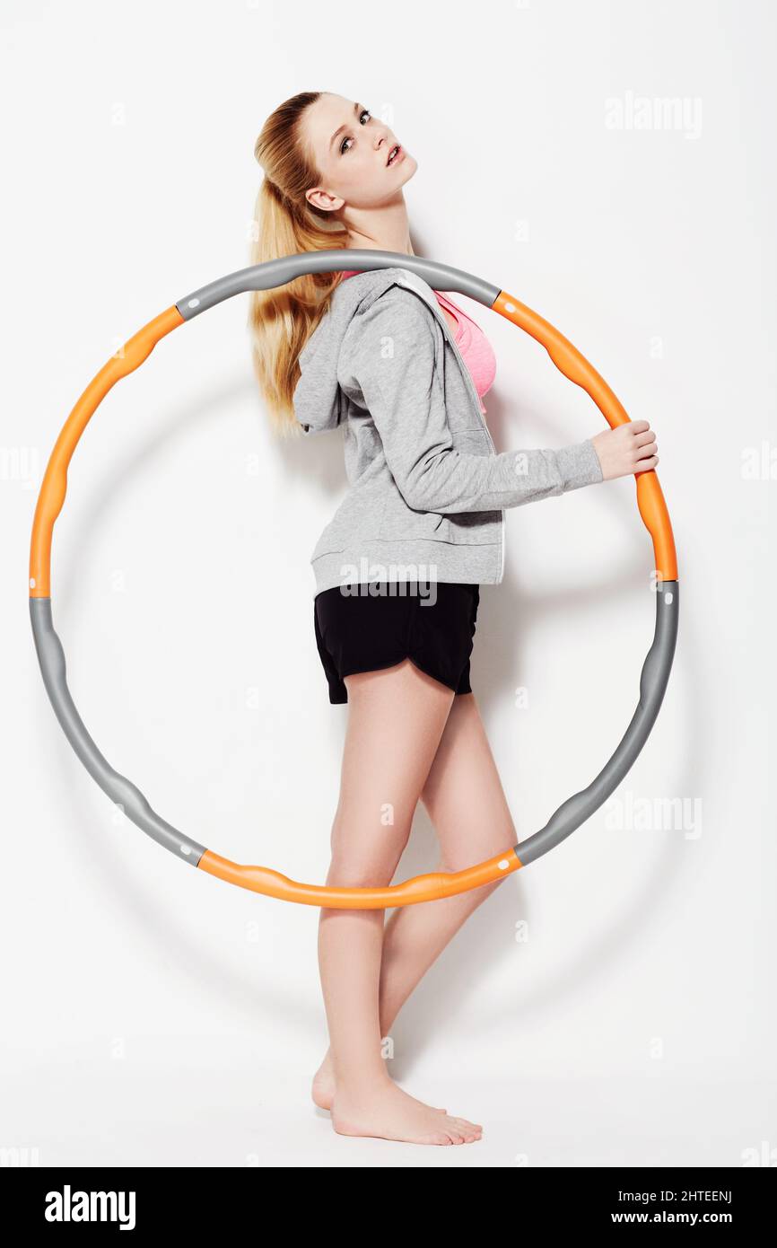 Holding her hula hoop. A gorgeous young woman holding a hula hoop in a ...