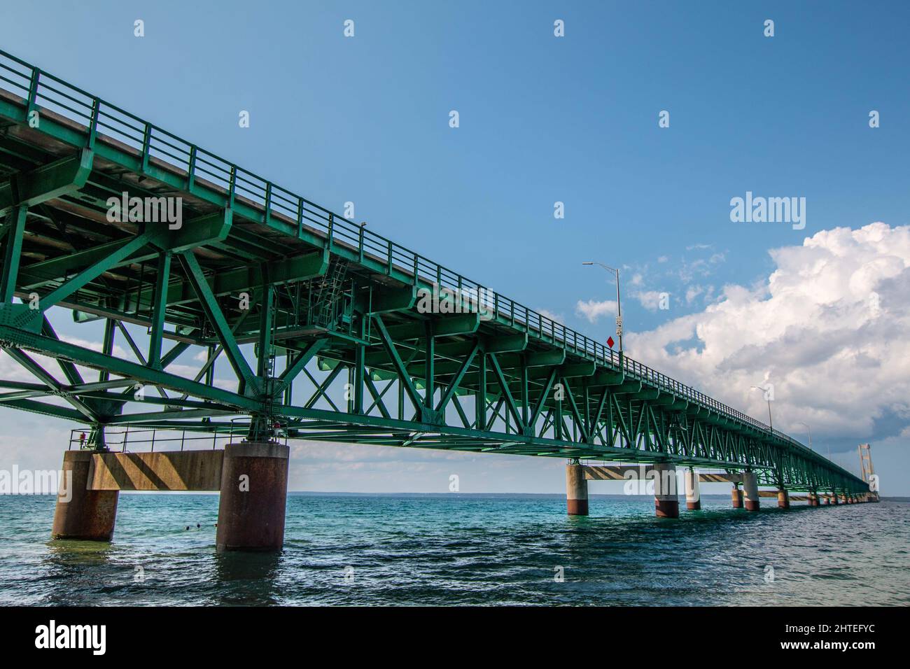 Long green pier under the sunny sky Stock Photo - Alamy