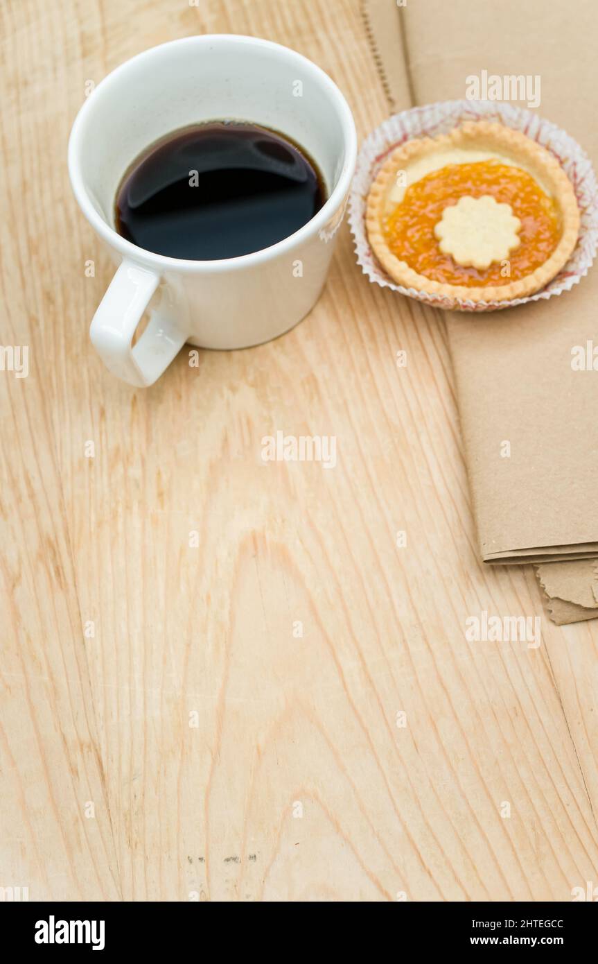 delicious jam short crust pastry and black coffee cup on a food paper ...