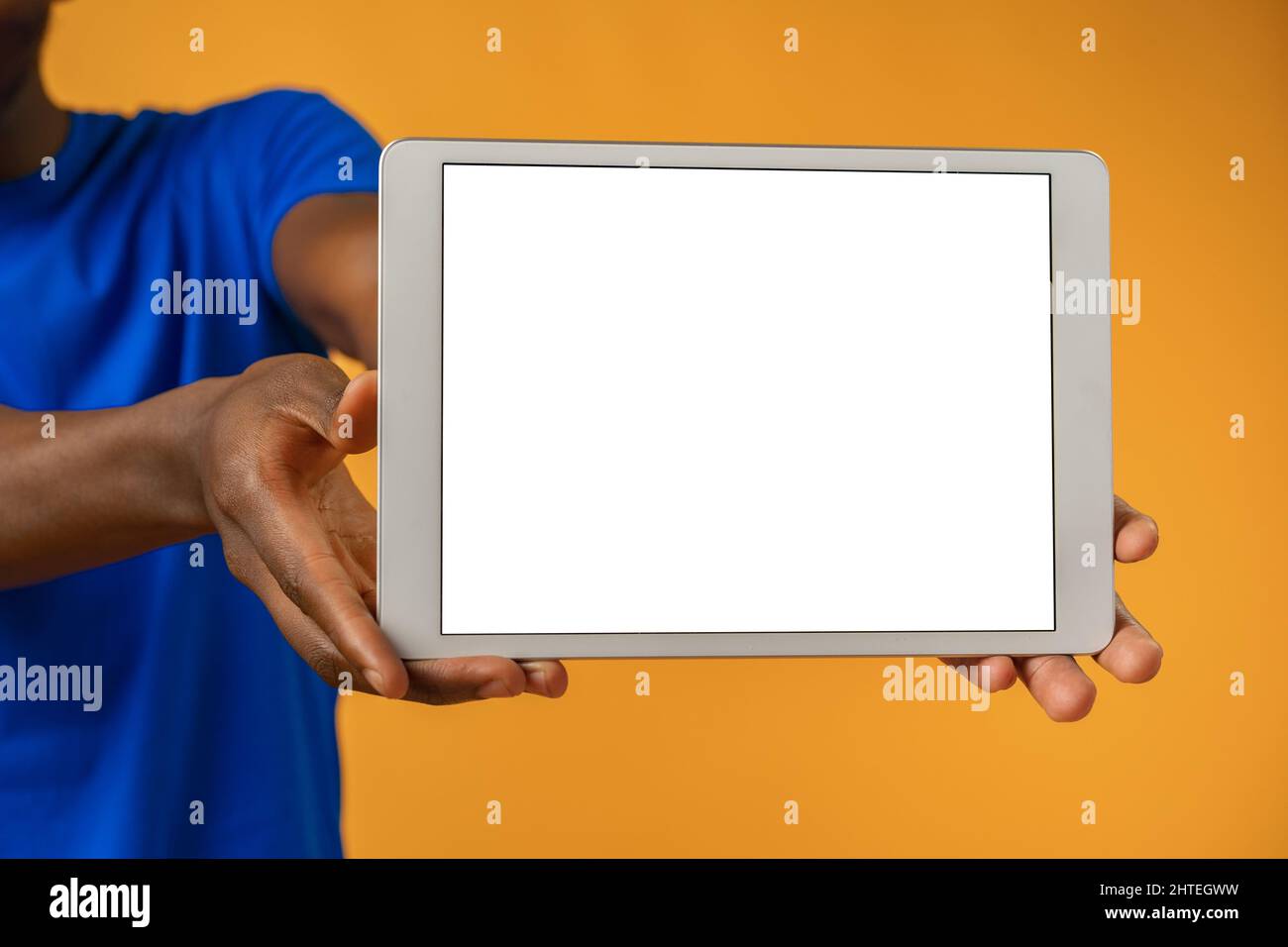 African man showing digital tablet over yellow background Stock Photo ...