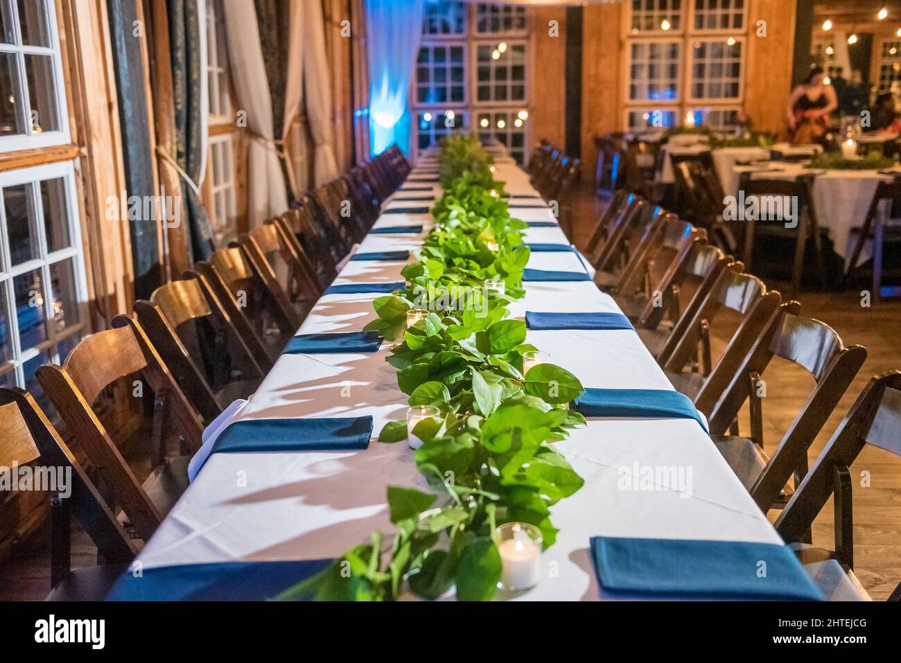 Long table for a large party with a leafy green greenery centerpiece ...