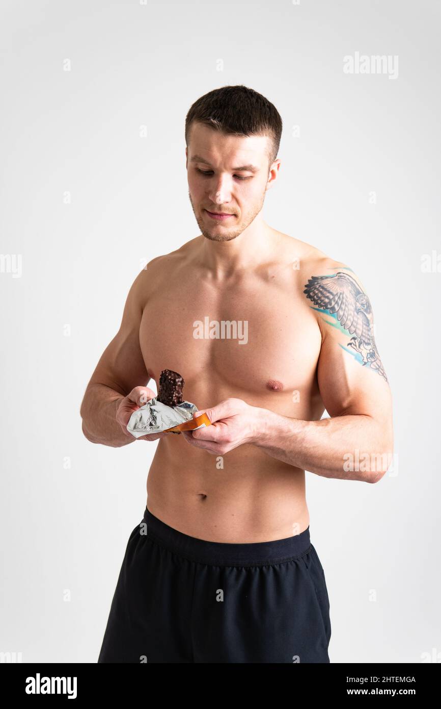 Man eats protein bar on white background isolated young healthy, man ...