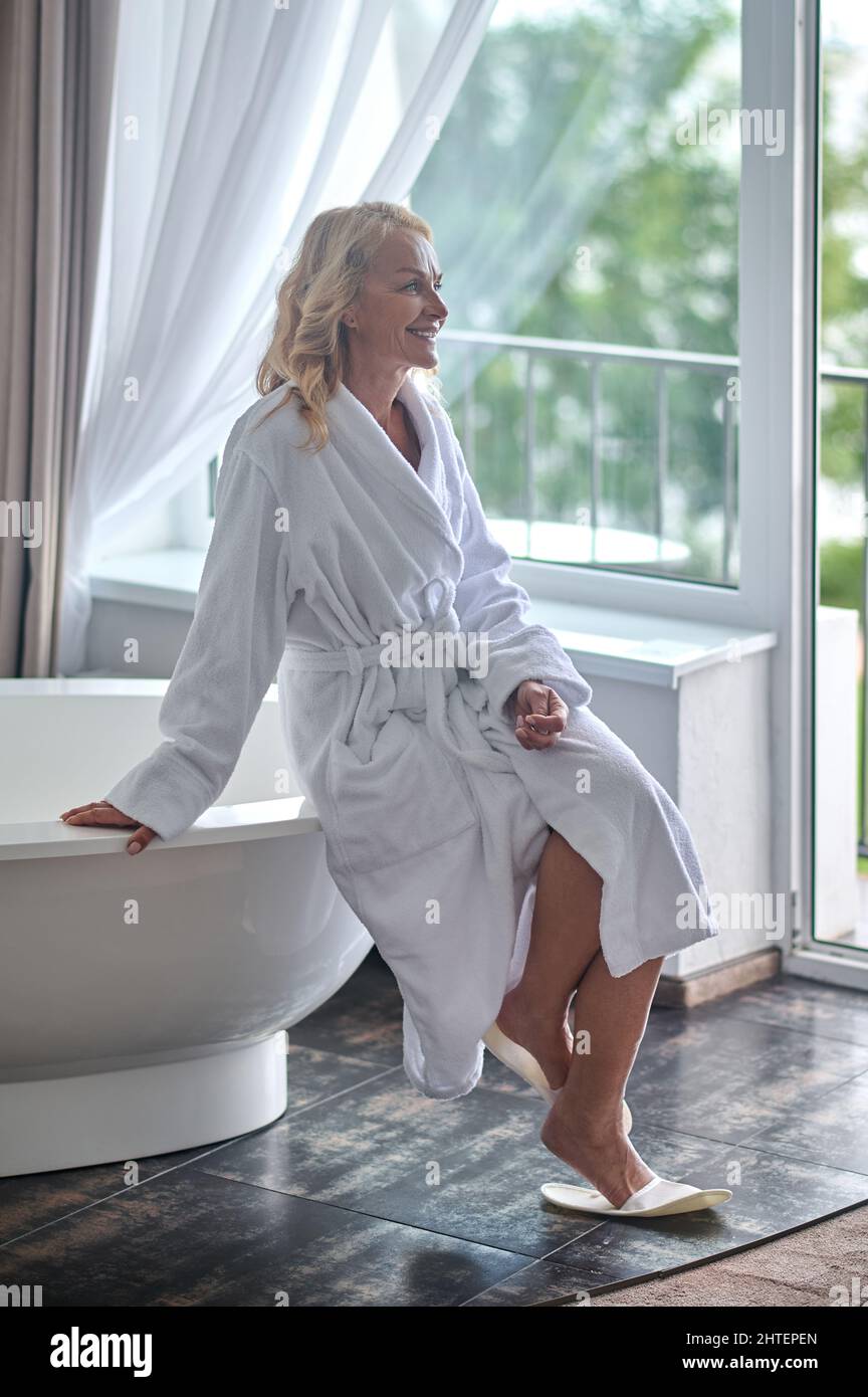 A blonde middle aged woman in a white robe Stock Photo - Alamy