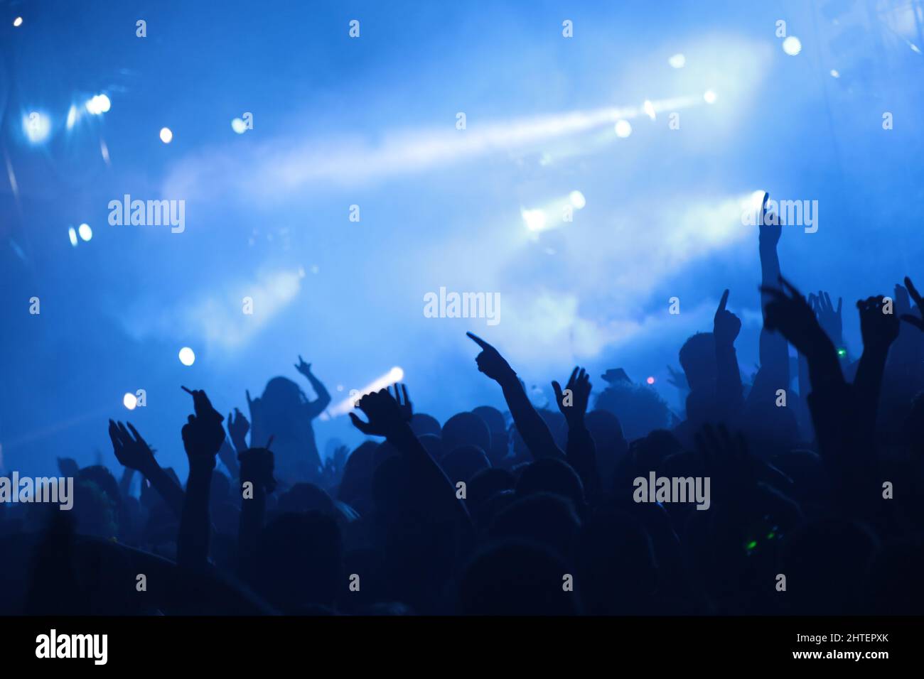 View of people with their hands up hanging out and enjoying the music ...