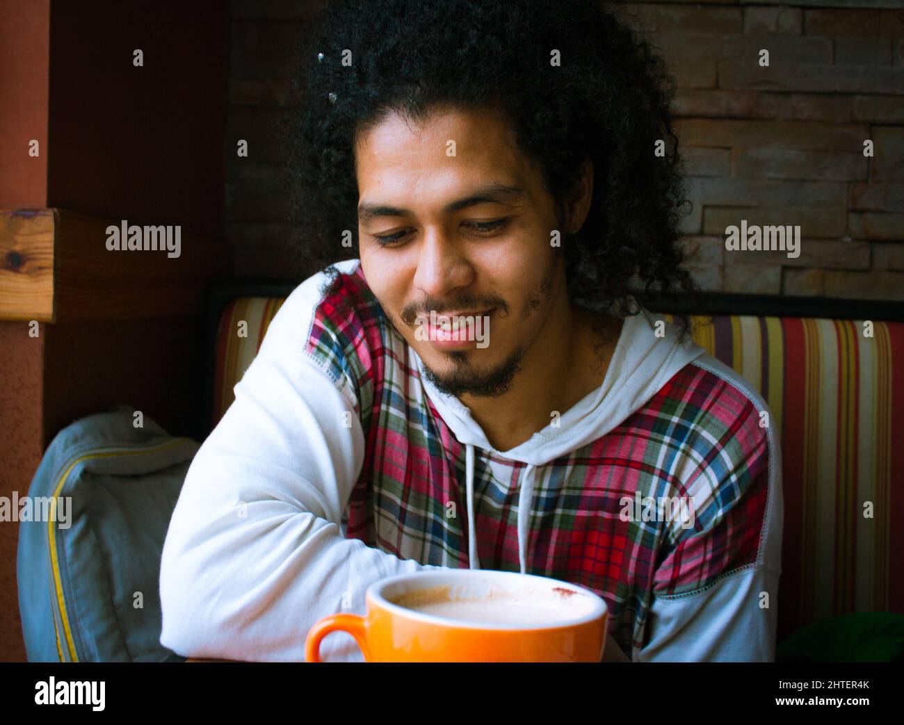 Adult Hispanic man drinking a cup of hot chai tea in a cafe Stock Photo ...