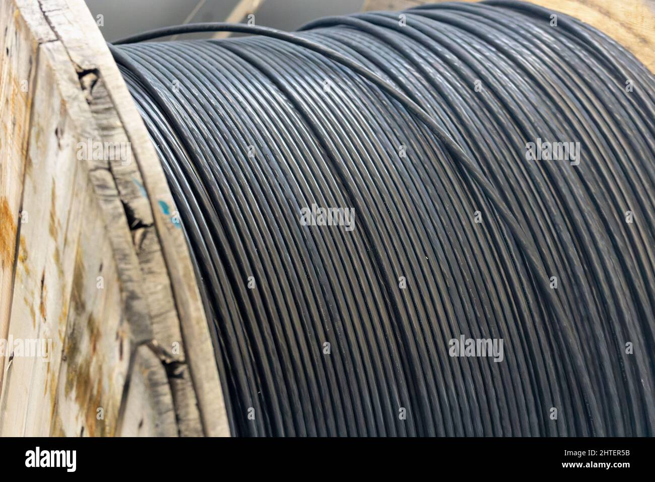 New black power cable is wound on wooden coil. Background. Cable for ...