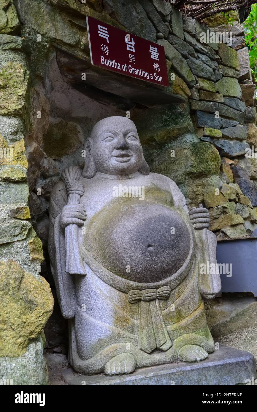Vertical shot Buddha of granting a son statue at Haedong Yonggungsa ...