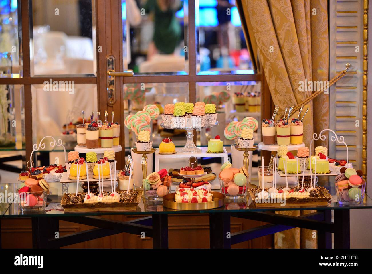 Shot of several types of sweets in plates on a table in a room Stock ...