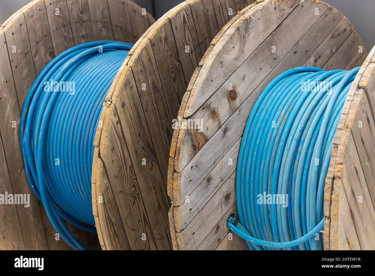 New blue power cable is wound on wooden coil. Background. Cable for ...