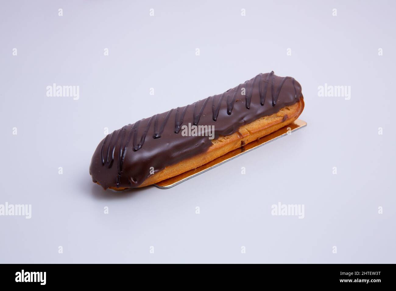 Close-up shot of a chocolate eclair isolated on a white background ...