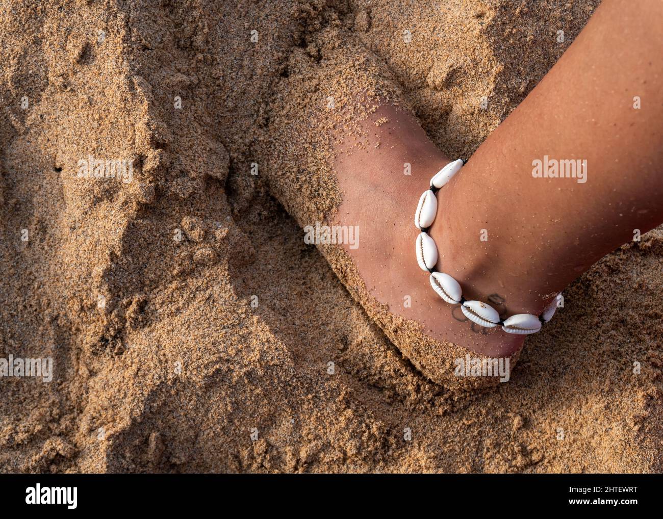 High angle shot of a foot in the sand on a beach during the day Stock ...