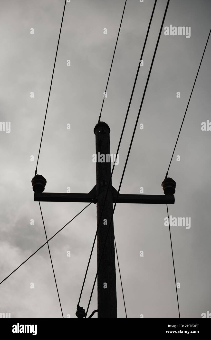 Vertical shot of an electric pole on the background of the gloomy sky ...