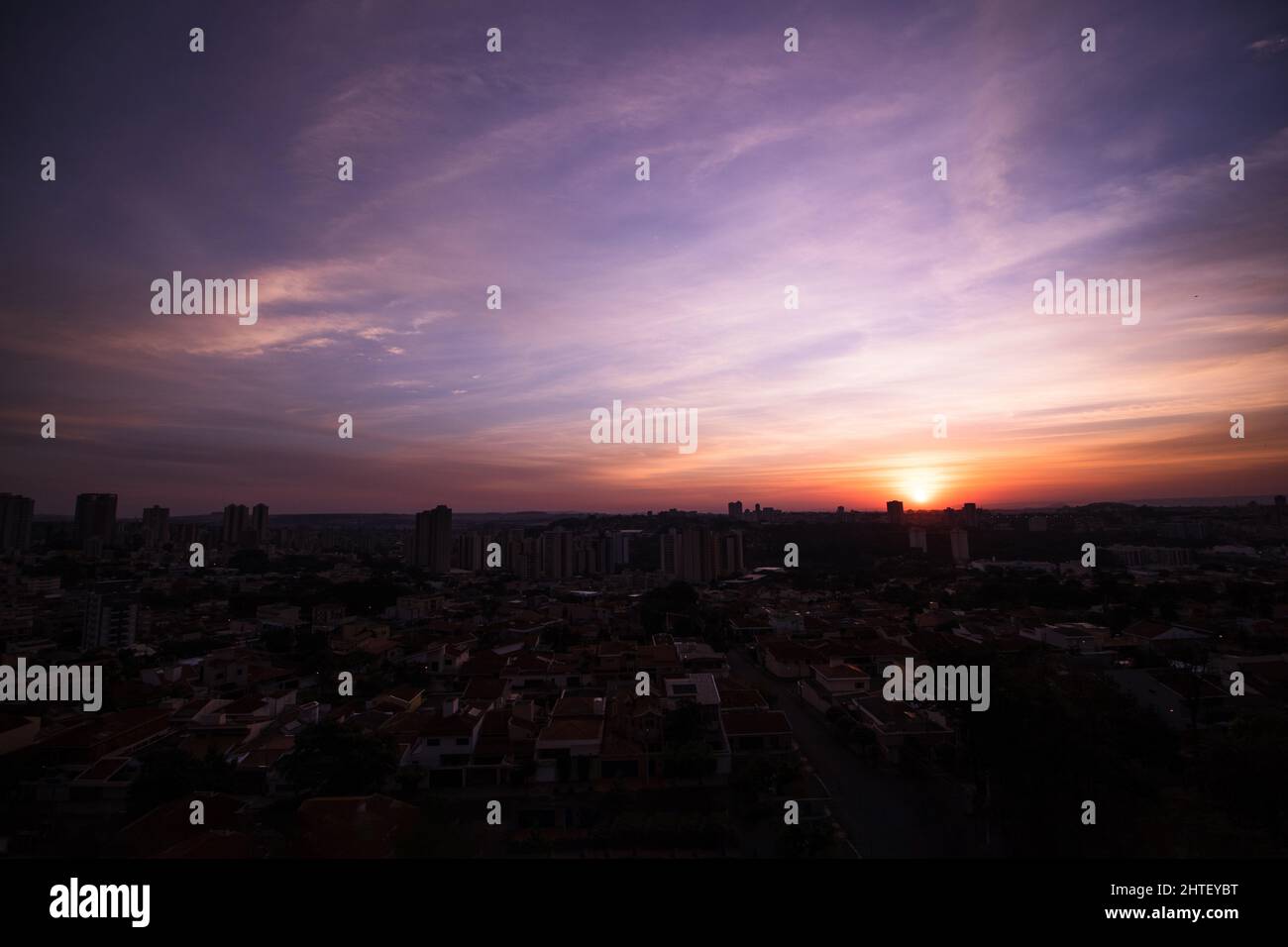 Rising sun with city silhouette skyline Stock Photo - Alamy