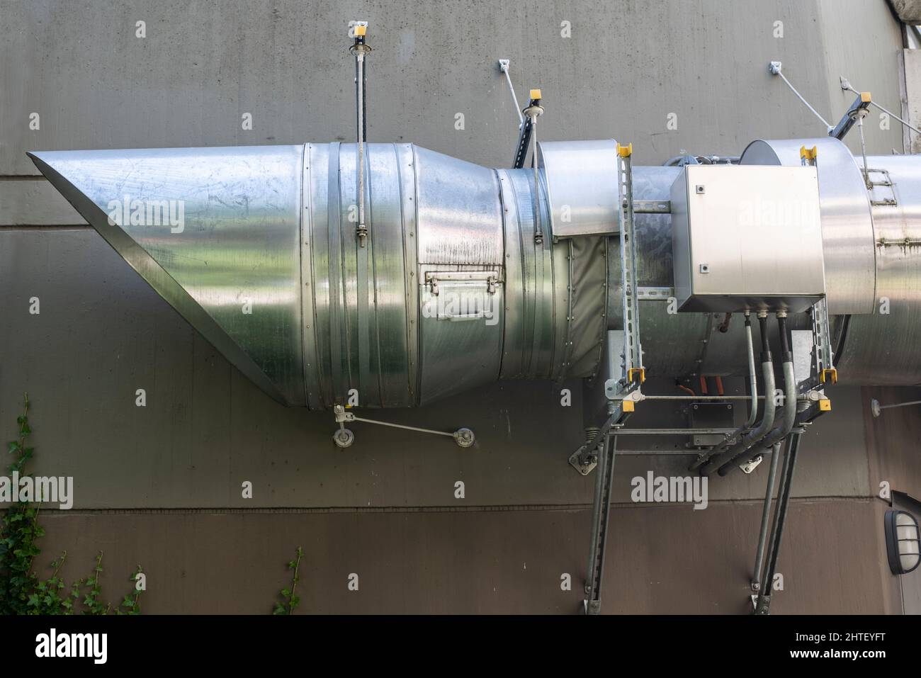 a large ventilation tube fixed at a gray concrete wall Stock Photo - Alamy