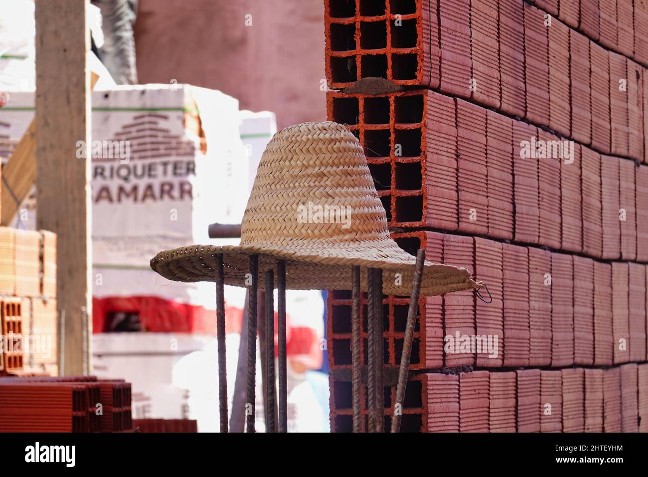 Straw hat on the rusty poles at the construction site Stock Photo - Alamy