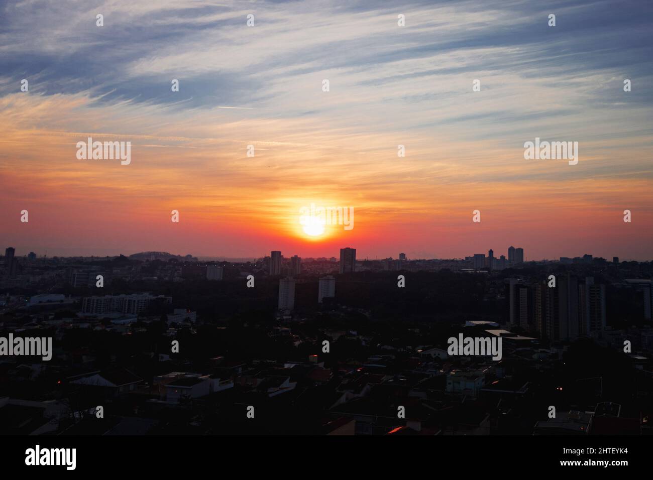 Rising sun with city silhouette skyline Stock Photo - Alamy