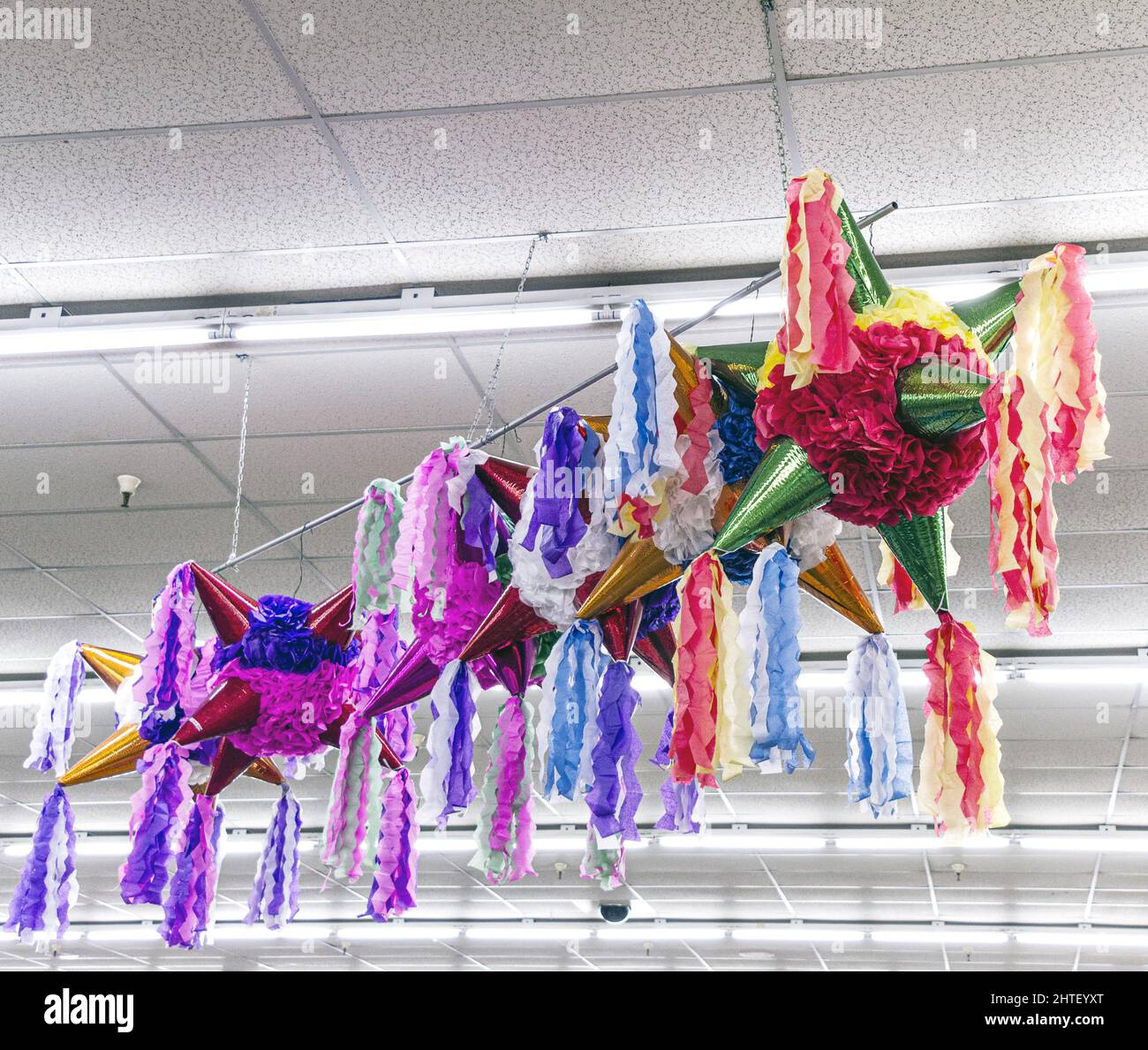 Low angle of colorful star-shaped pinatas hanging from the ceiling in a ...