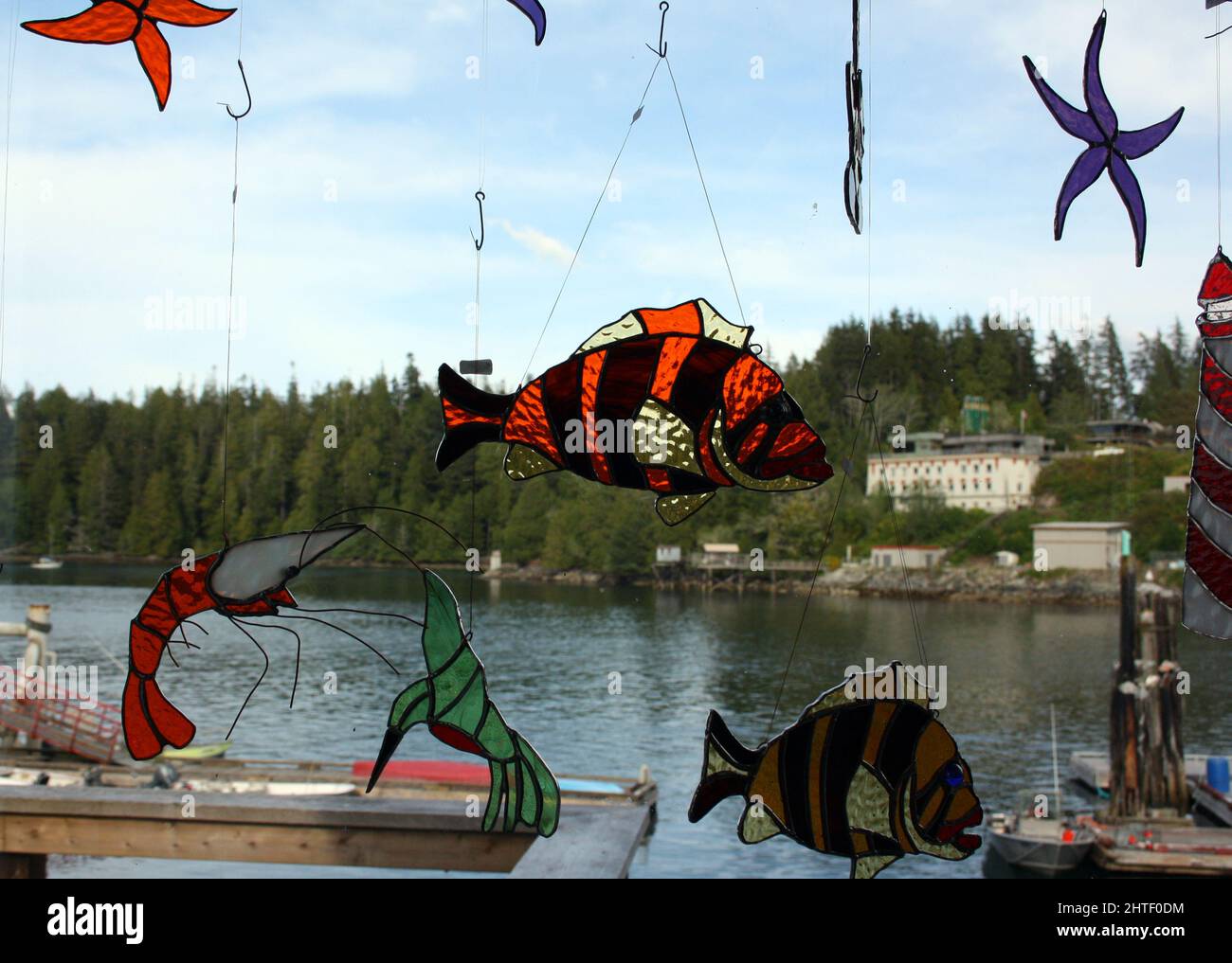 Colorful stained glass fish figures hanging on the window of a shop in ...