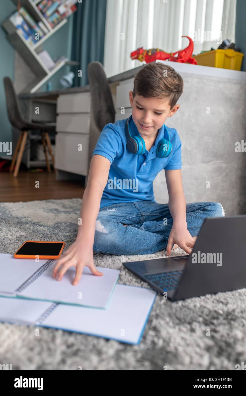 Concentrated smiling boy learning alone at home Stock Photo - Alamy