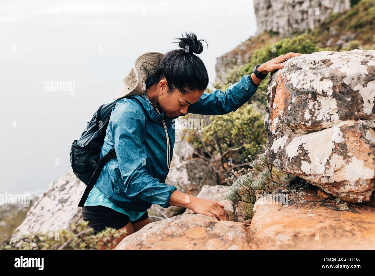 Woman hiker look where she steps while climbing up on a mountain Stock ...