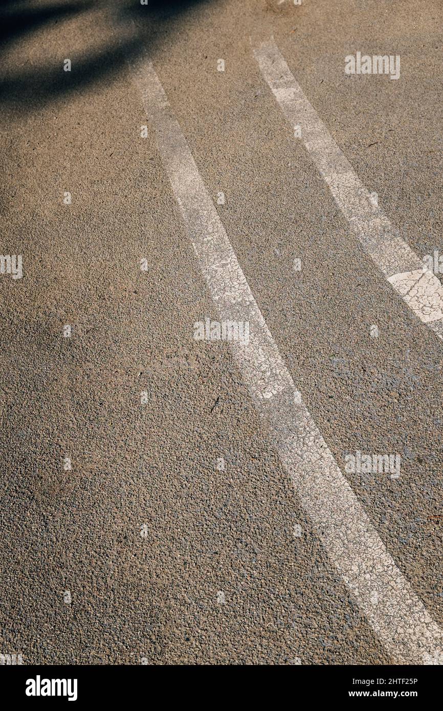Vertical shot of an asphalt road with faded white lines Stock Photo - Alamy