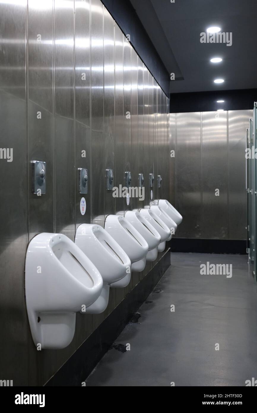 Public men's toilets lined up on the wall Stock Photo - Alamy