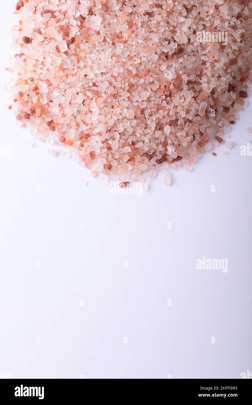Close-up of himalayan pink rock salt on white background with copy ...