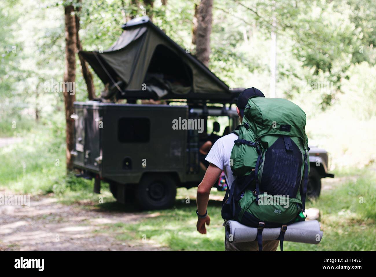 View of a hiker with a backpack walking to a camper van Stock Photo - Alamy