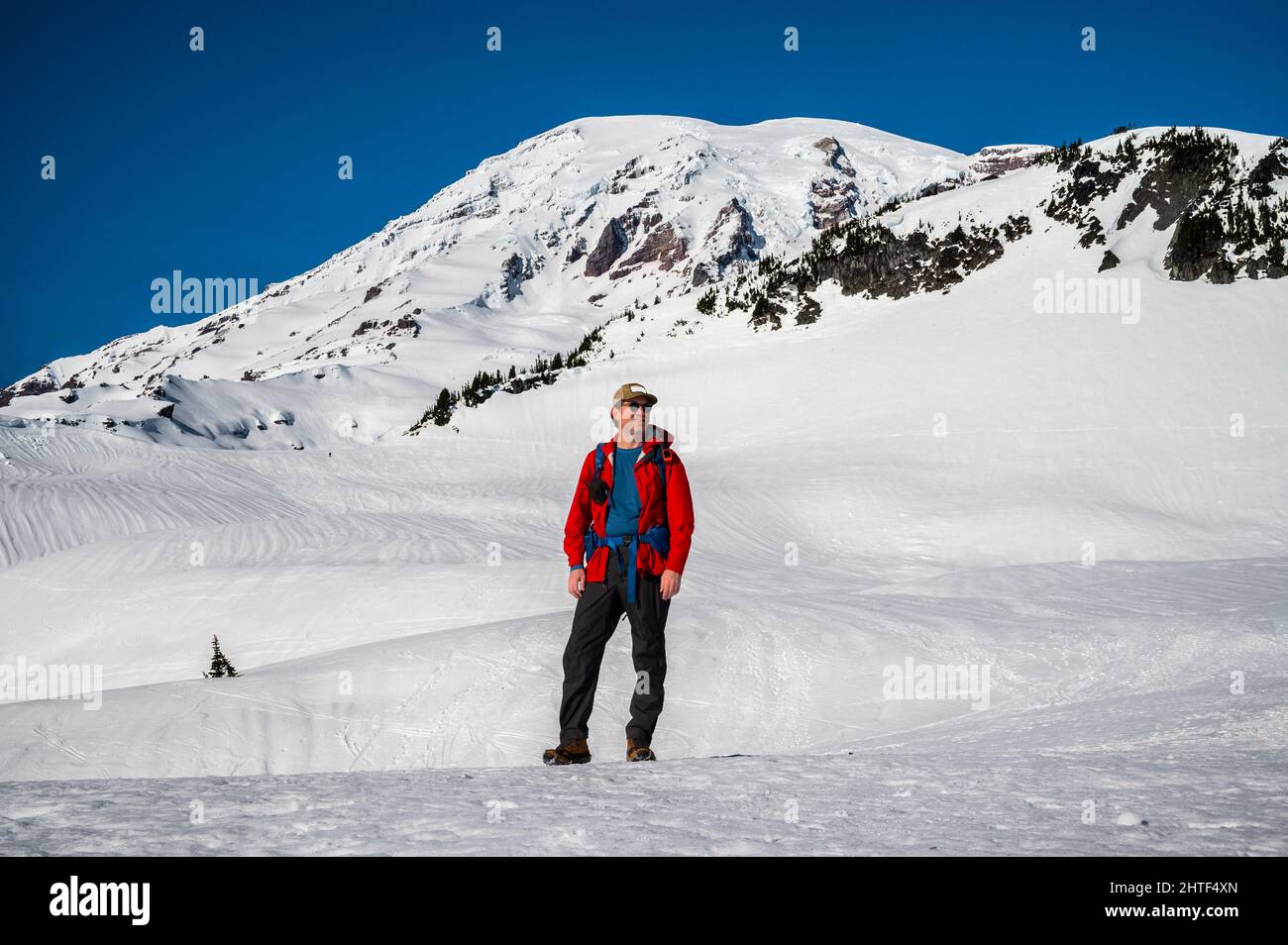 Male posing in front of Mount Rainier in the winter Stock Photo - Alamy