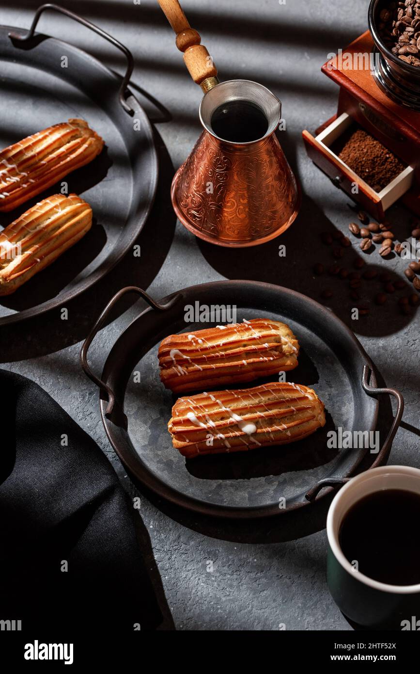 Coffee eclairs on a vintage plate, coffee, coffee grinder Stock Photo ...