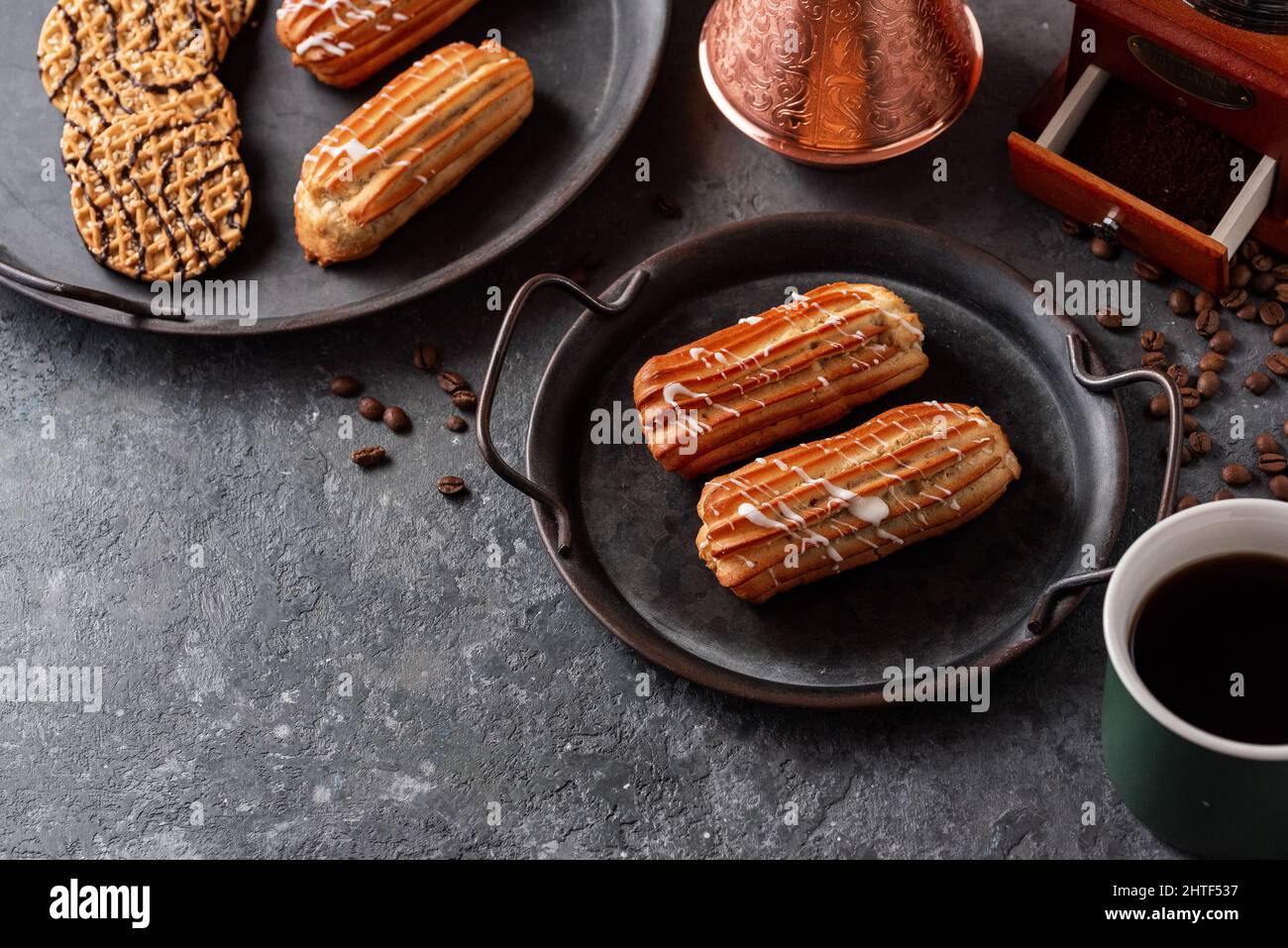 Coffee eclairs on a vintage plate, coffee, coffee grinder Stock Photo ...