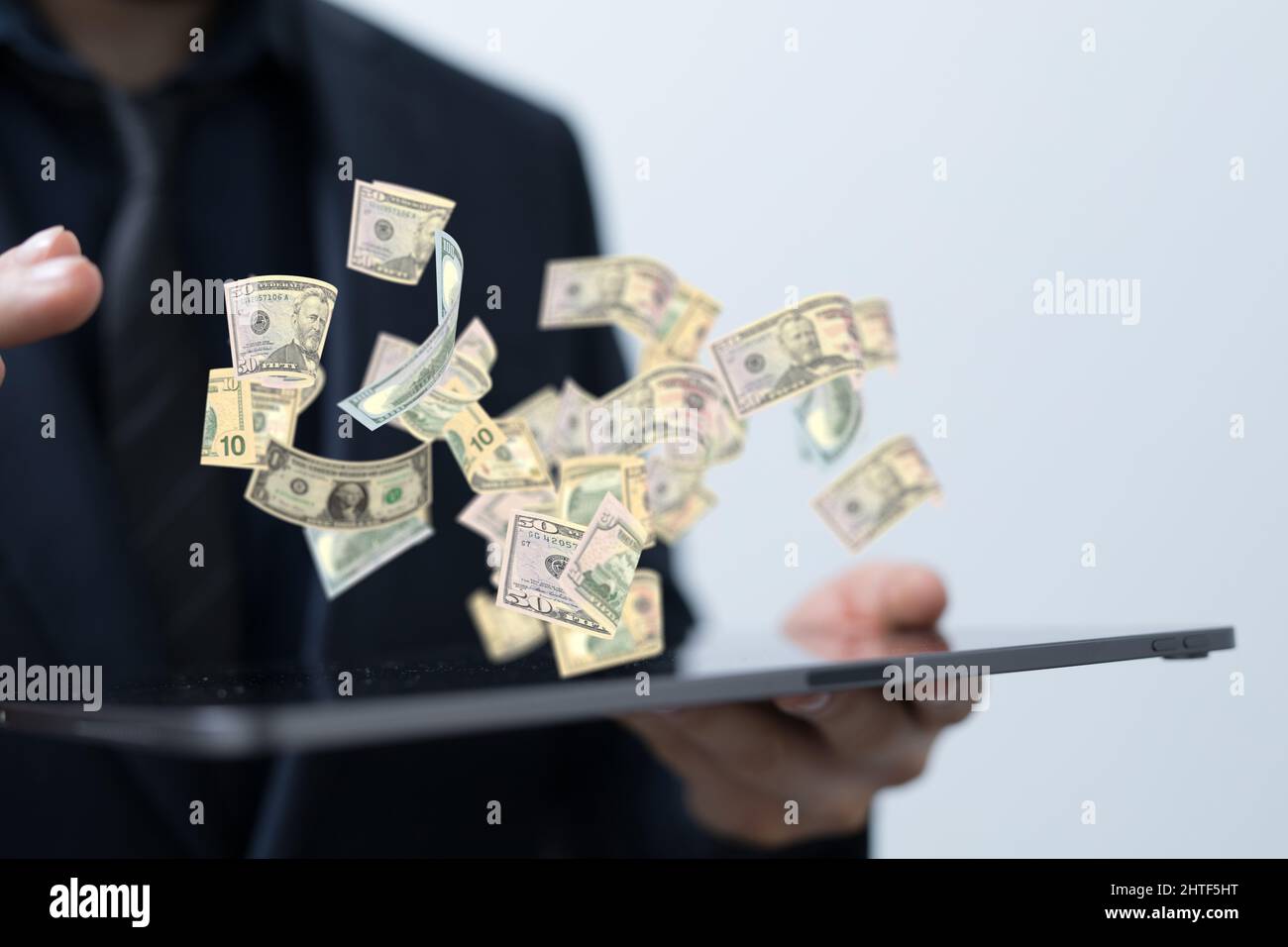 3d rendering of falling US dollar banknotes over a tablet on a white ...