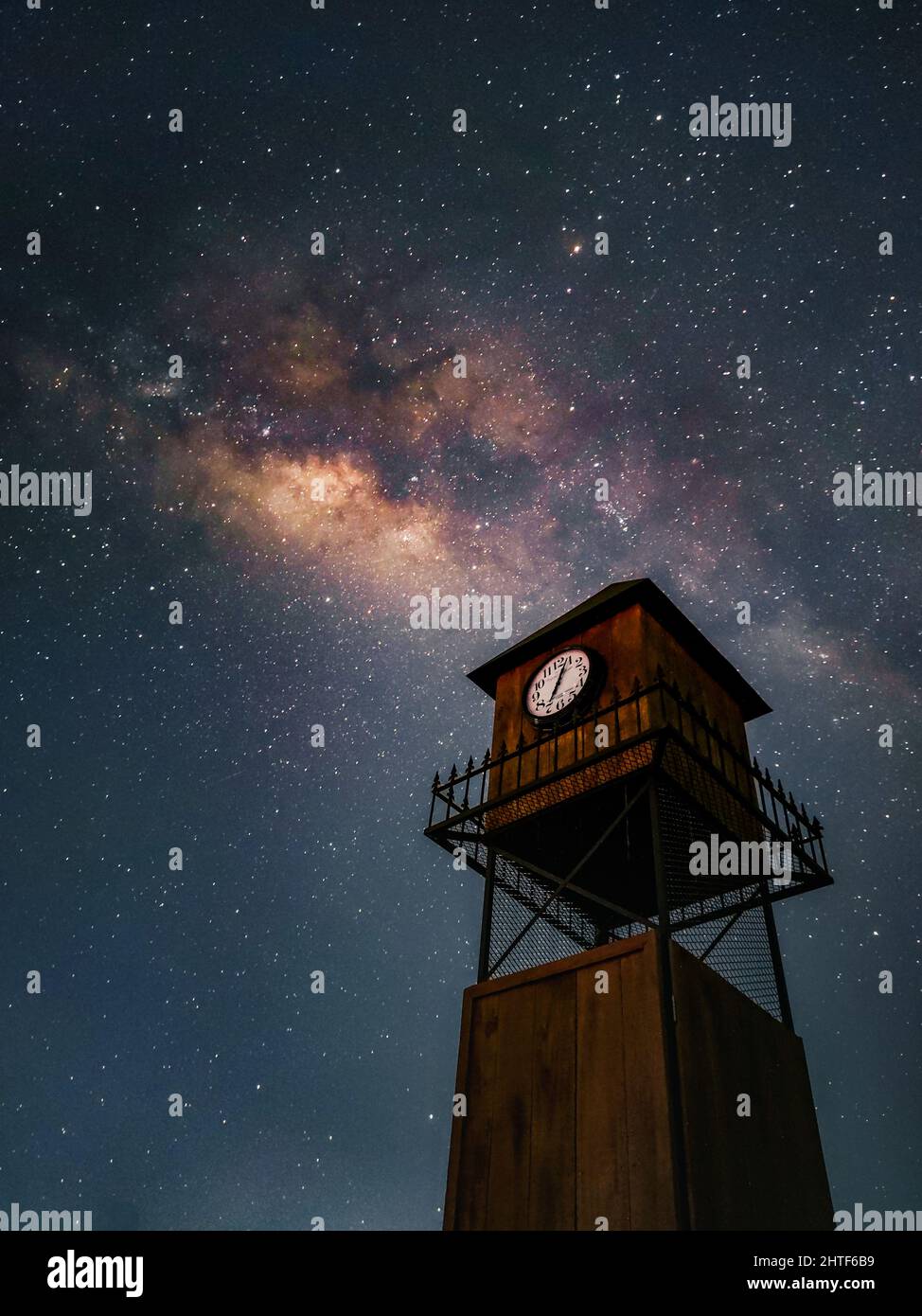 Wooden tower with a clock on a starry night Stock Photo - Alamy