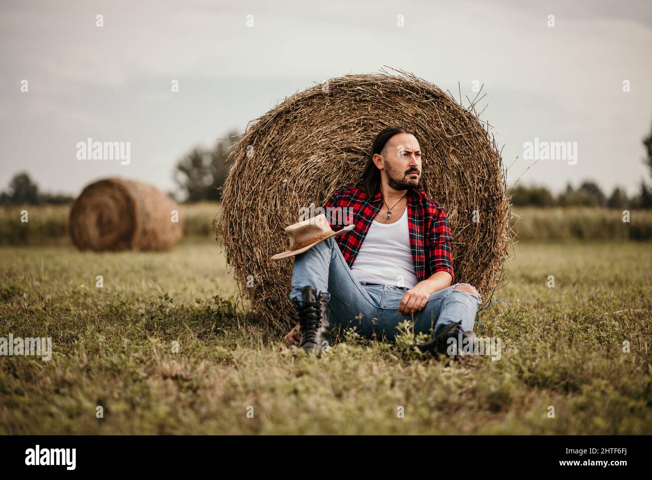 Young handsome Serbian male in a flannel shirt and ripped jeans sitting ...