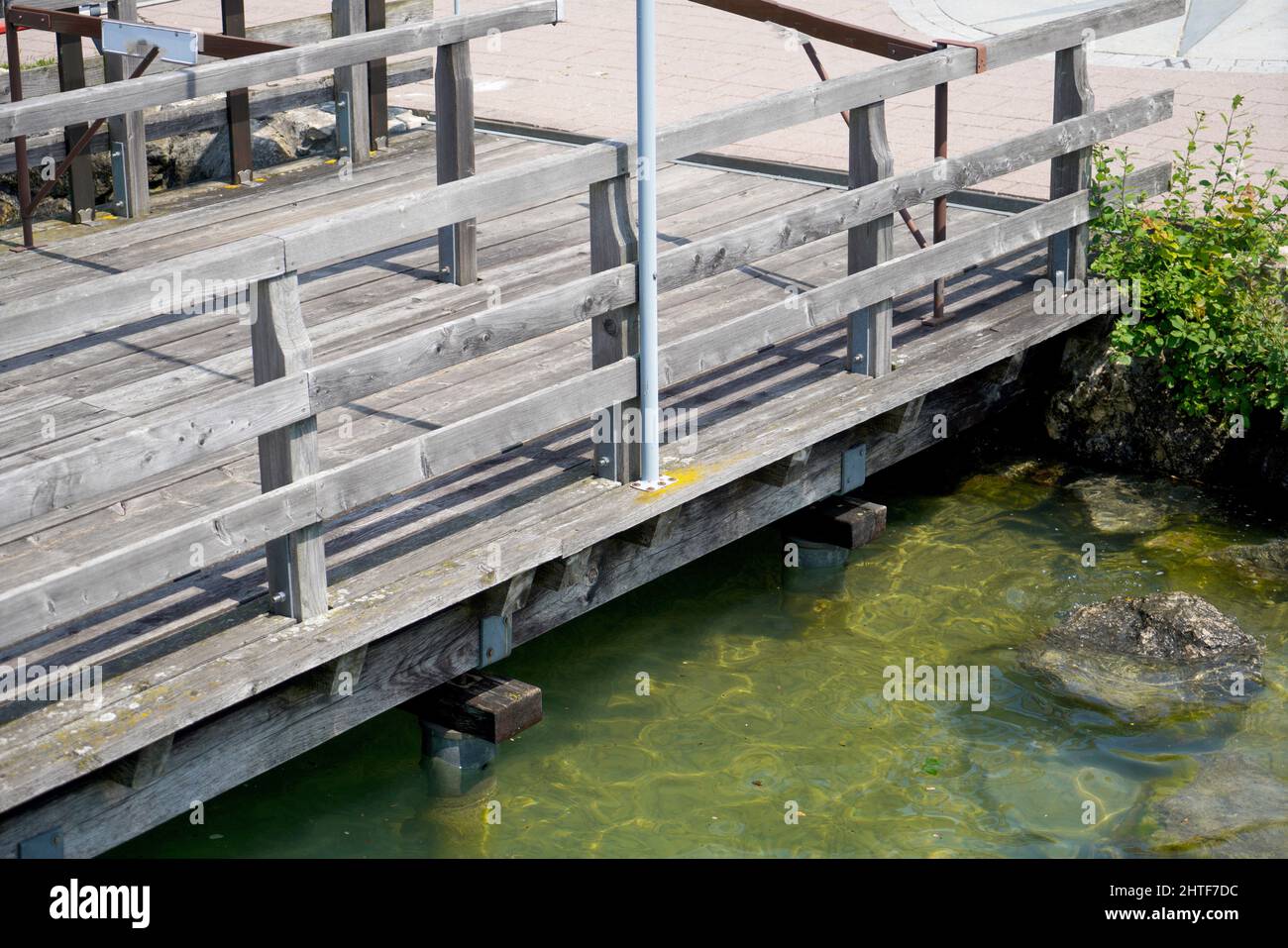 Wooden bridge over water with rocks under the sunlight Stock Photo - Alamy