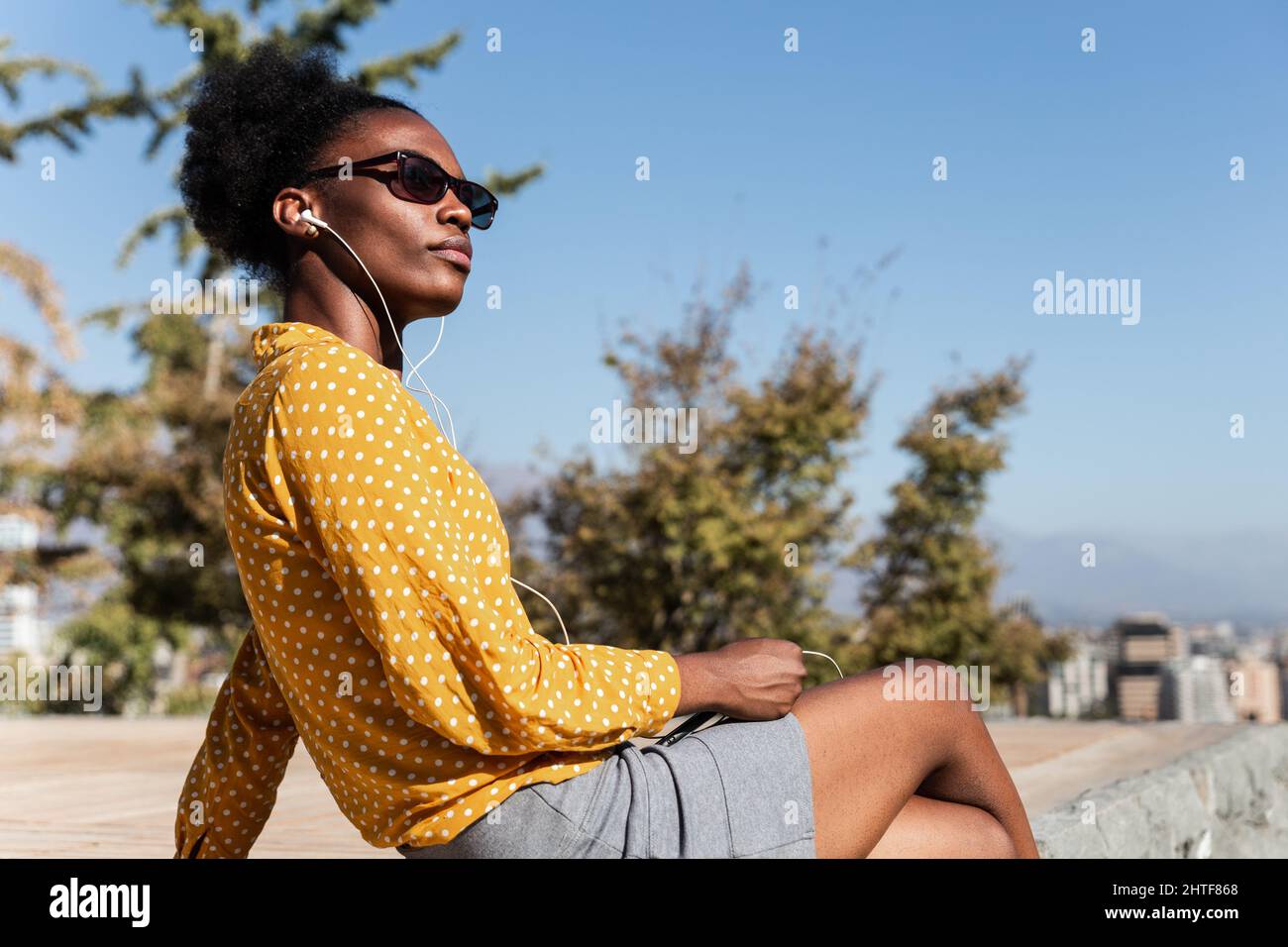Beautiful Black Female Listening To Music Using Her Mobile Phone And