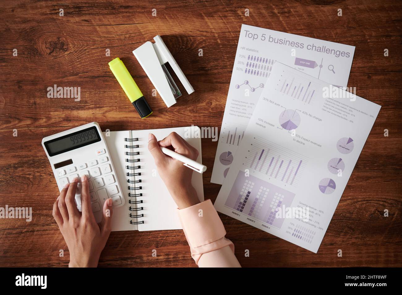 Hands of manager analyzing financial charts, making calculations and ...