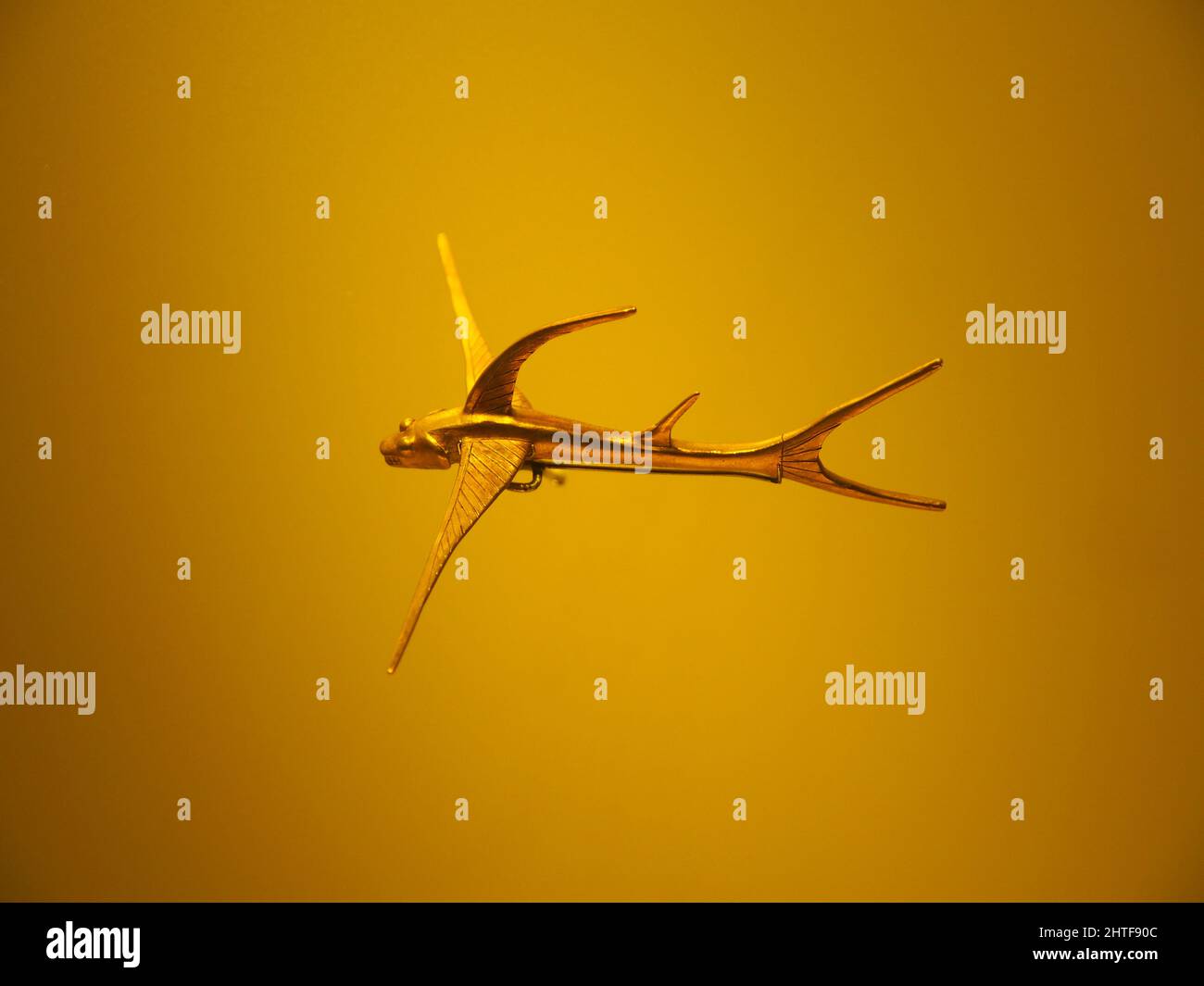 Golden bird isolated in a yellow background in Cartagena, Colombia ...
