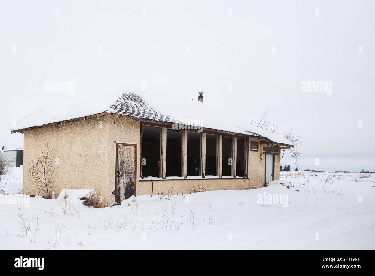 An old stucco building with missing long narrow windows in a cold ...