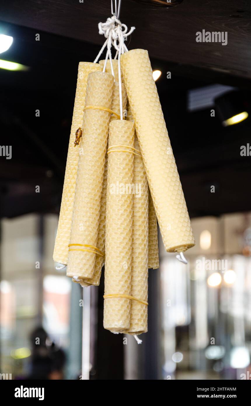 A bunch of wax candles tied together and hung on a market stall Stock ...