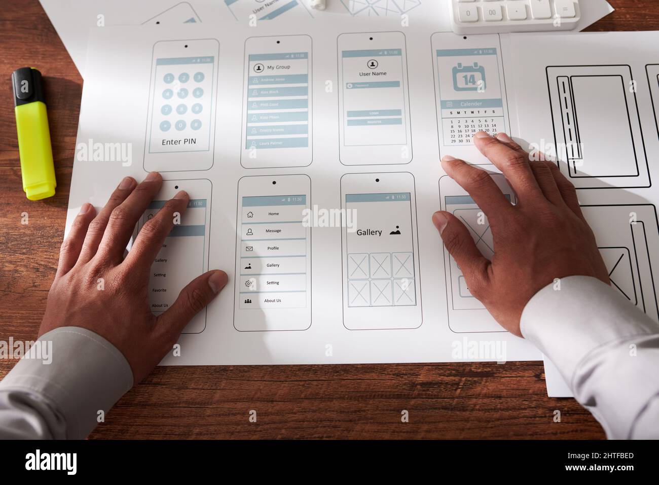 UX designer checking mock-ups of moble application interface he created ...