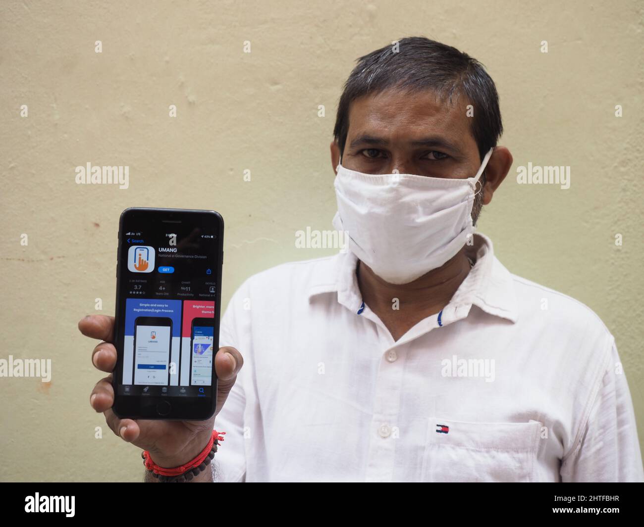 an indian man showing a app on play store in phone Stock Photo - Alamy