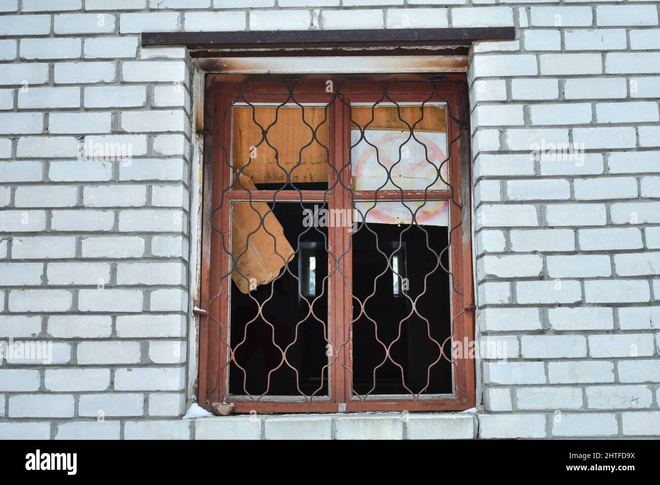 Broken window with an old wooden frame on a white brick wall of a ...