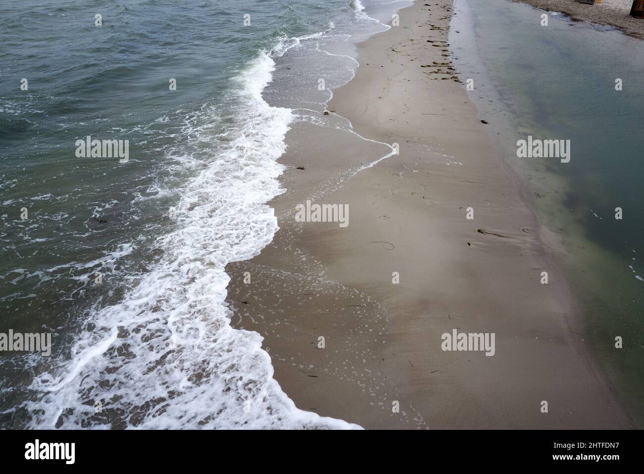 Sand beach with low tide waves on a gloomy day Stock Photo - Alamy